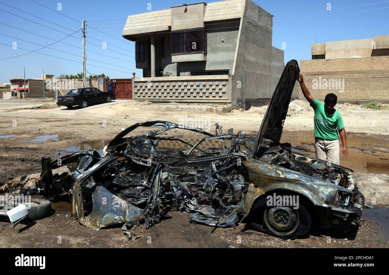 An iraqi man views a car used in a car bomb explosion, in Baghdad, Iraq ...