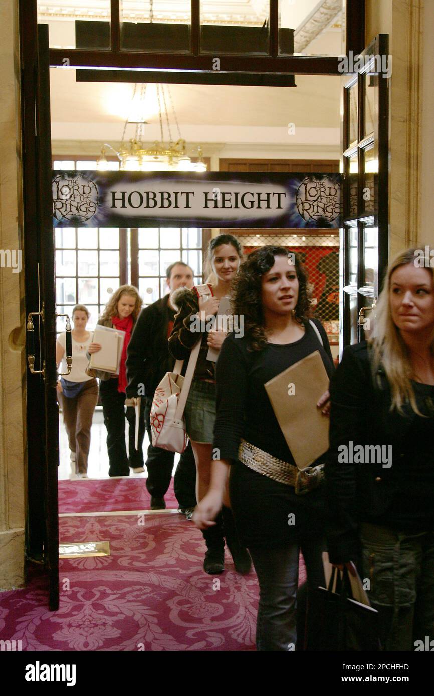 Hopeful people pass under a 'Hobbit Height' indicator as they enter the ...