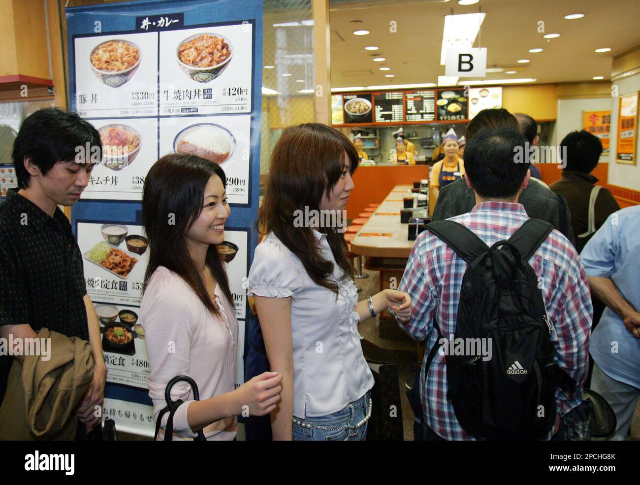 A line of customers enter a Yoshinoya fast-food restaurant to eat ...