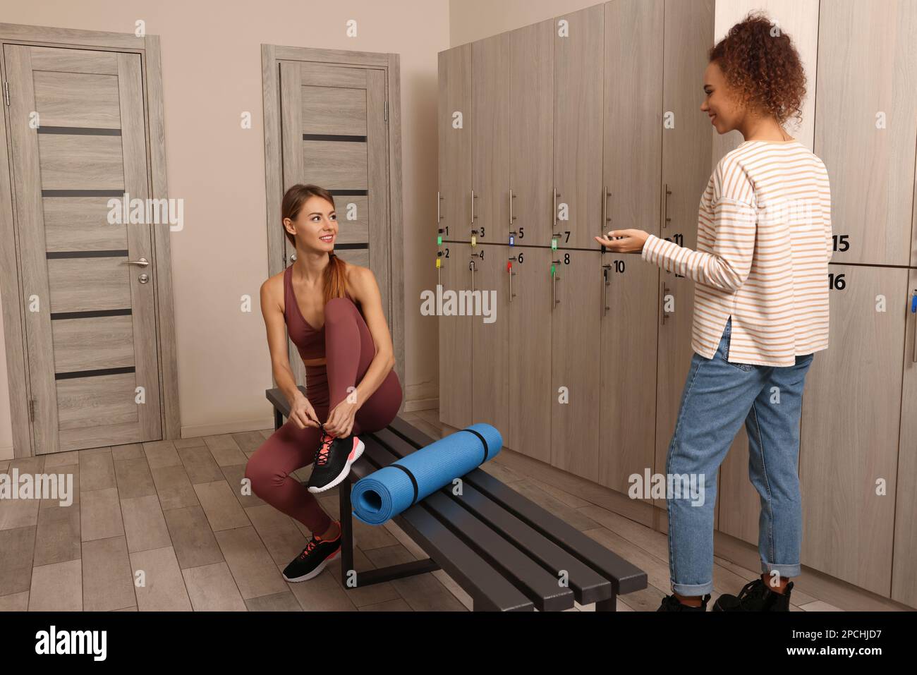 Beautiful happy women talking in locker room Stock Photo - Alamy