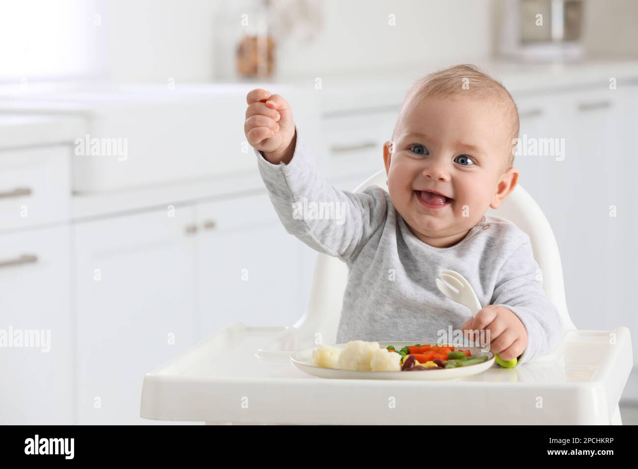 Cute little baby eating healthy food at home. Space for text Stock ...