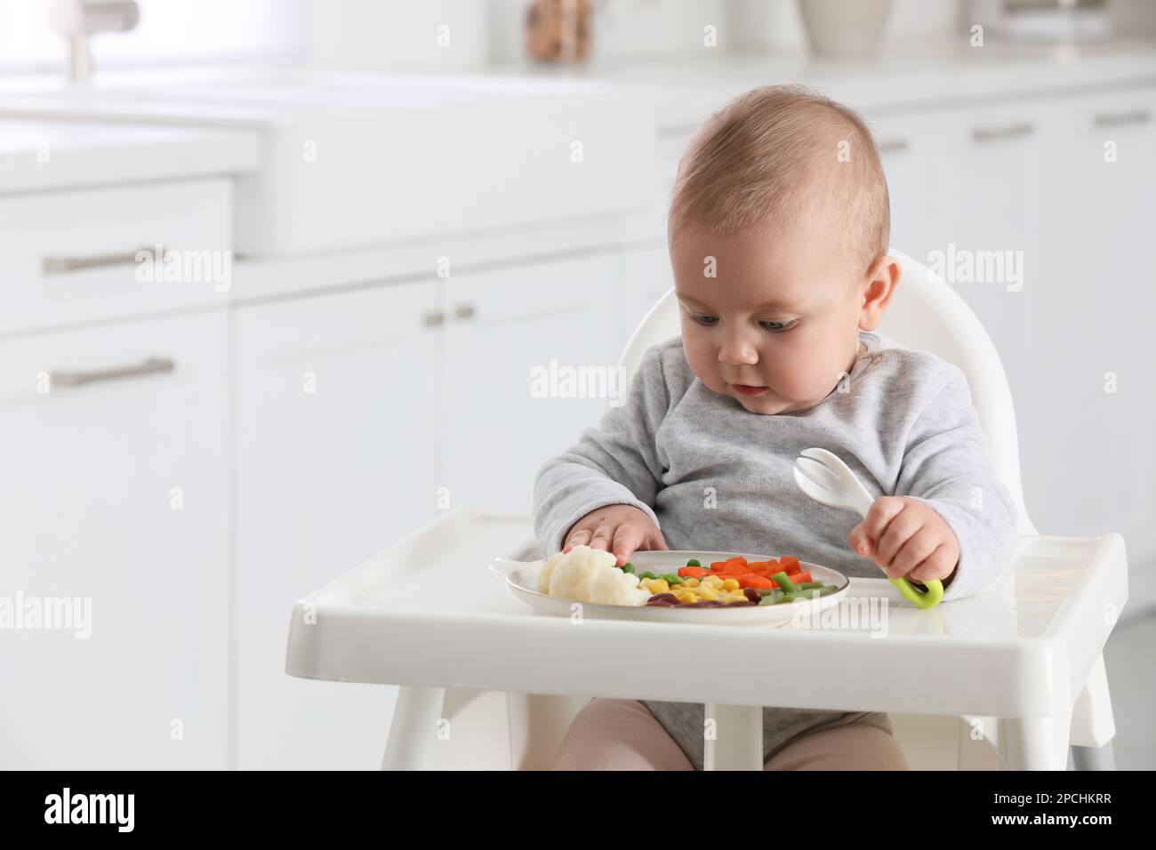 Cute little baby eating healthy food at home. Space for text Stock ...