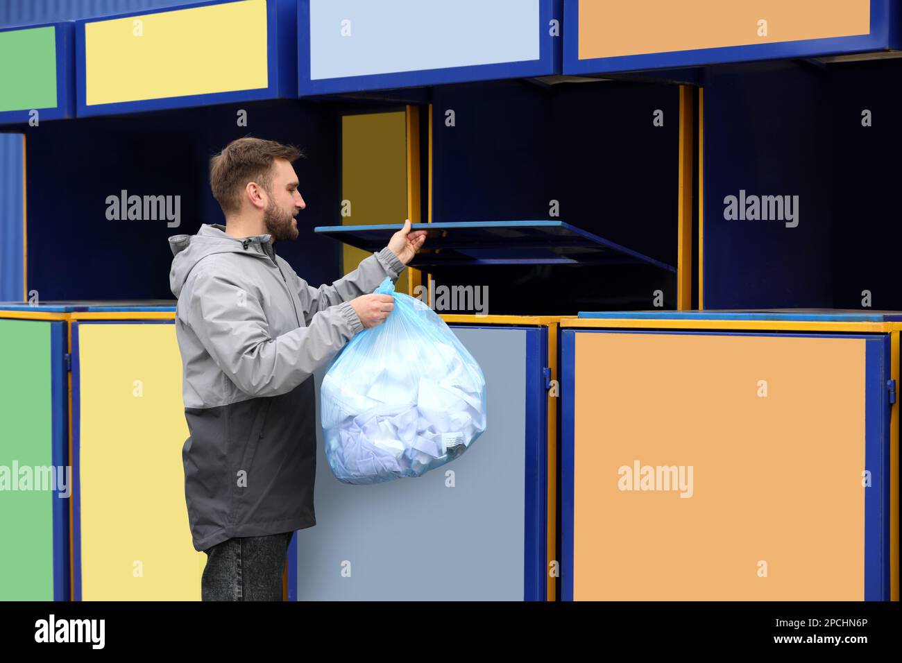 Man throwing garbage into bin at recycling point outdoors Stock Photo ...
