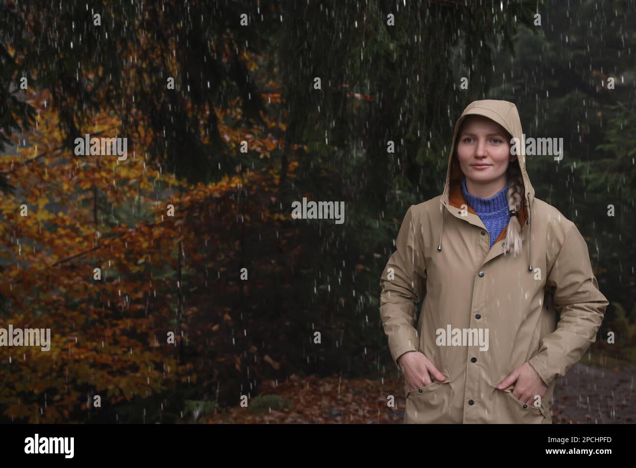 Young woman with raincoat in forest under rain Stock Photo - Alamy