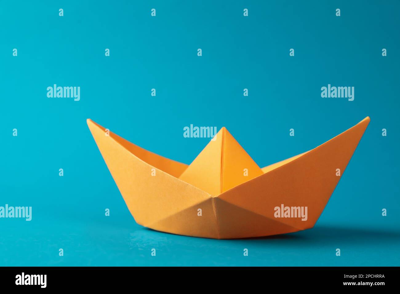 Handmade orange paper boat on light blue background. Origami art Stock ...