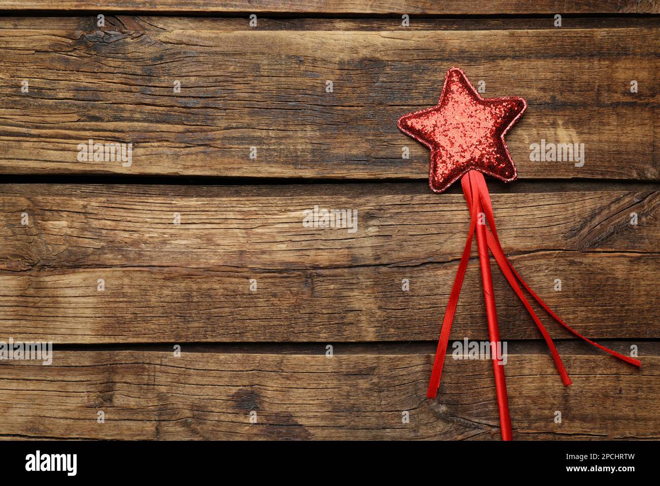 Beautiful red magic wand on wooden table, top view. Space for text ...