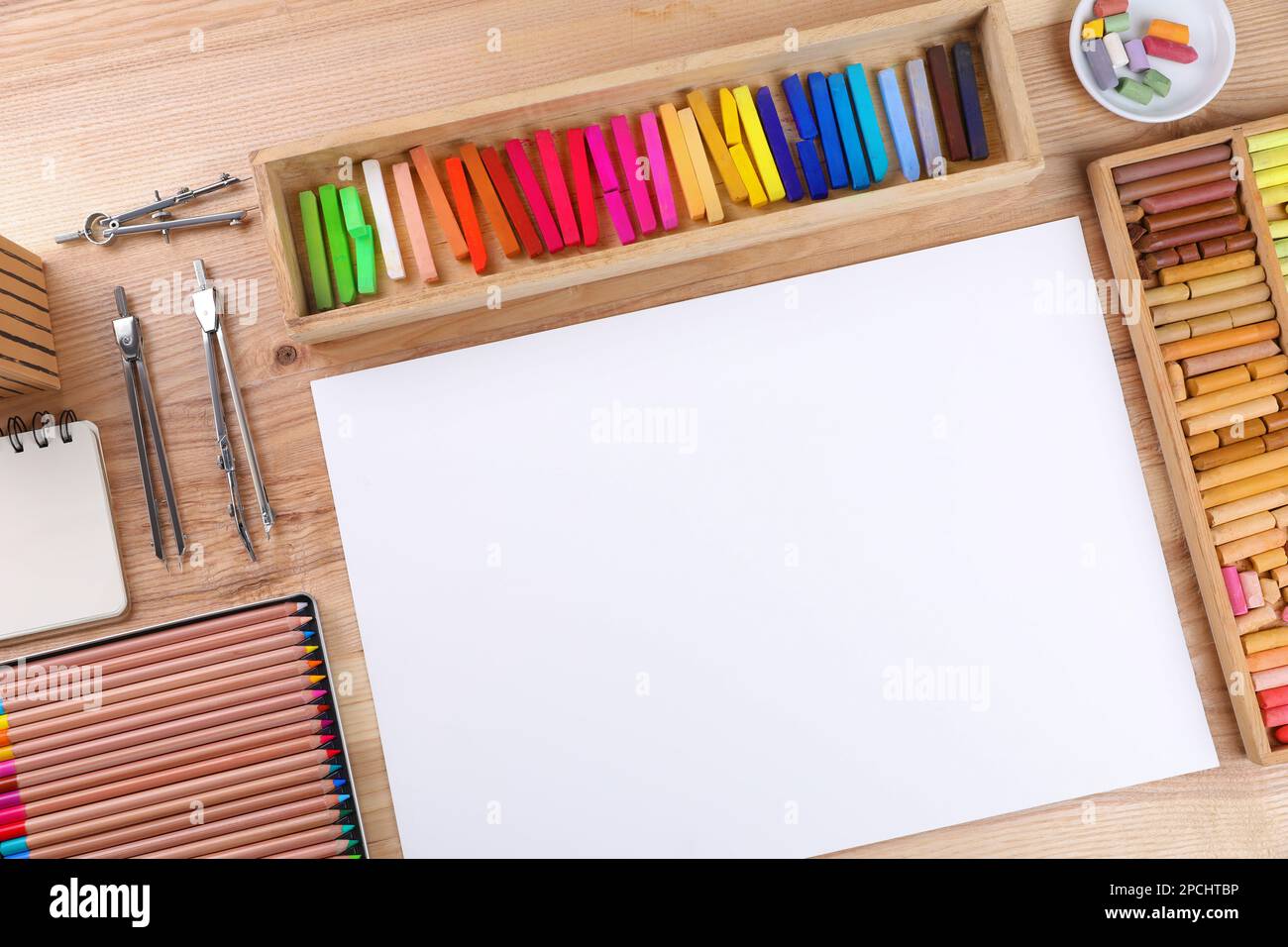Layout with blank paper, soft pastels and other drawing supplies on ...