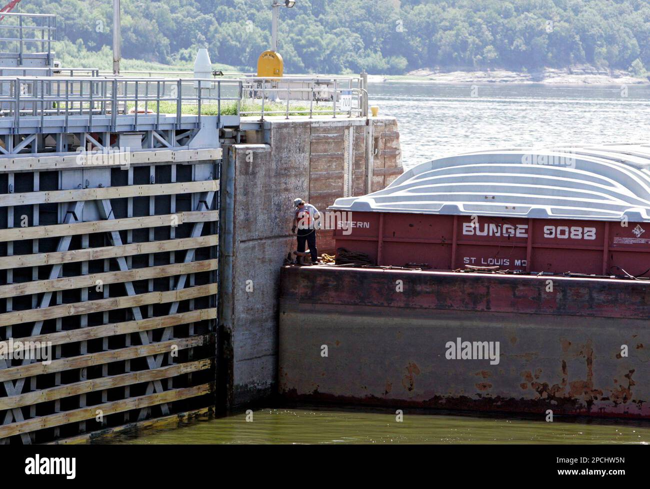 **FILE**A barge worker uses padded ropes to guide a barge into the ...