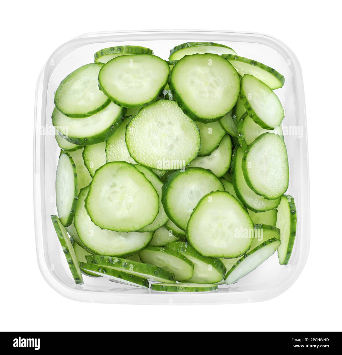 Fresh sliced cucumbers in plastic container isolated on white, top view ...