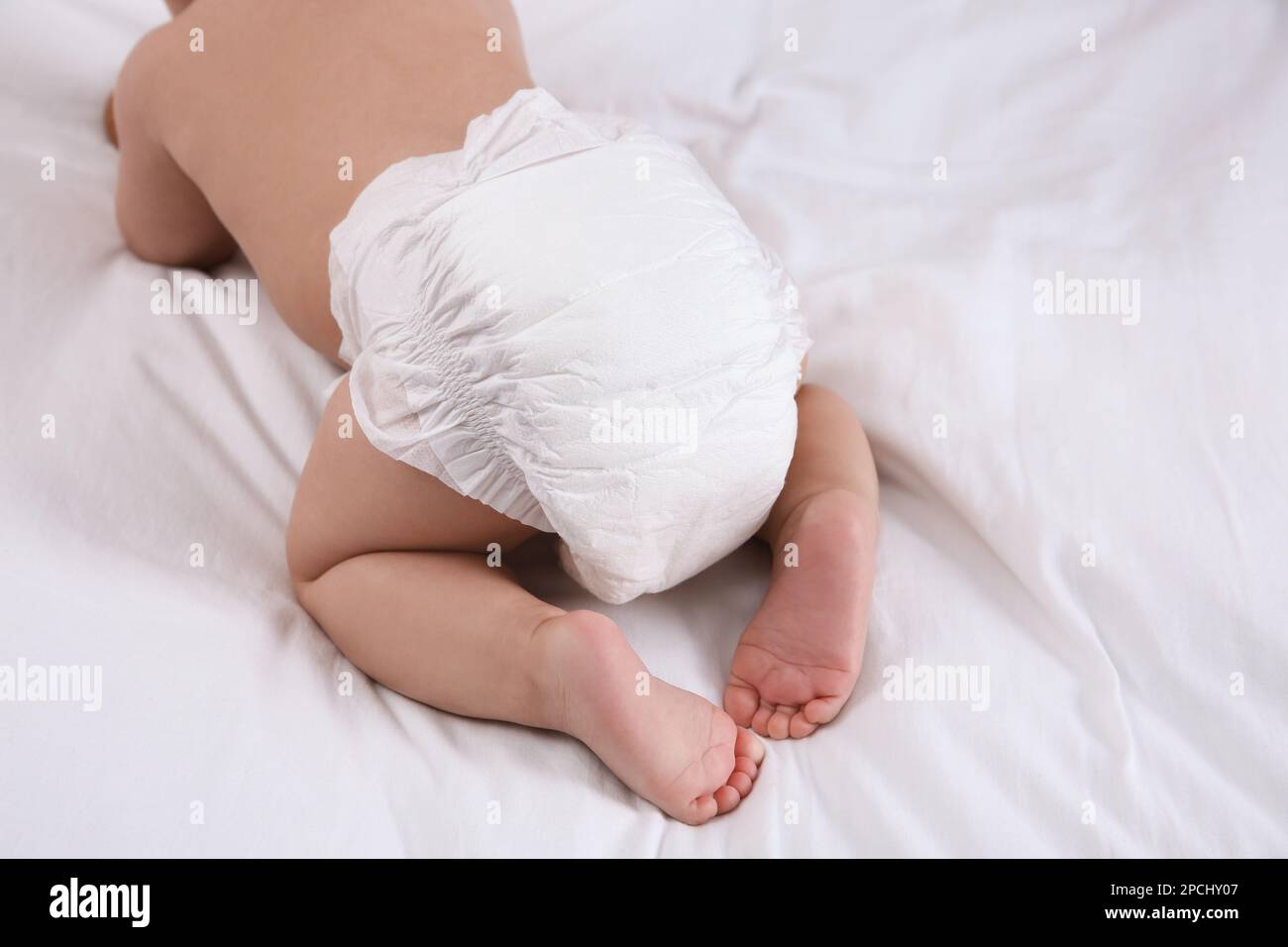 Cute baby in dry soft diaper on white bed, closeup Stock Photo - Alamy