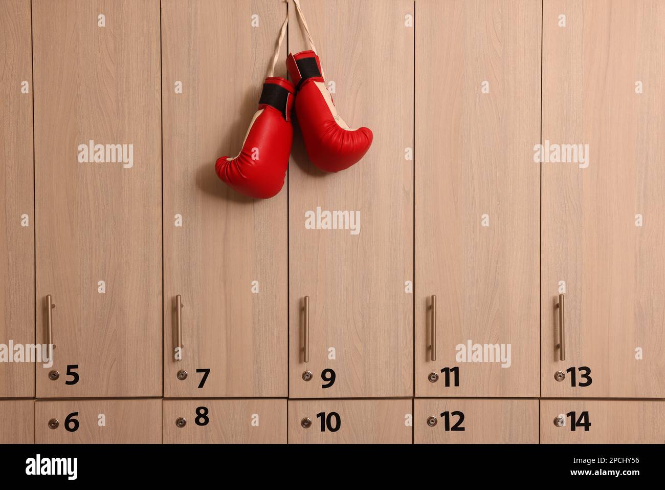 Red boxing gloves hanging on locker door in changing room Stock Photo ...