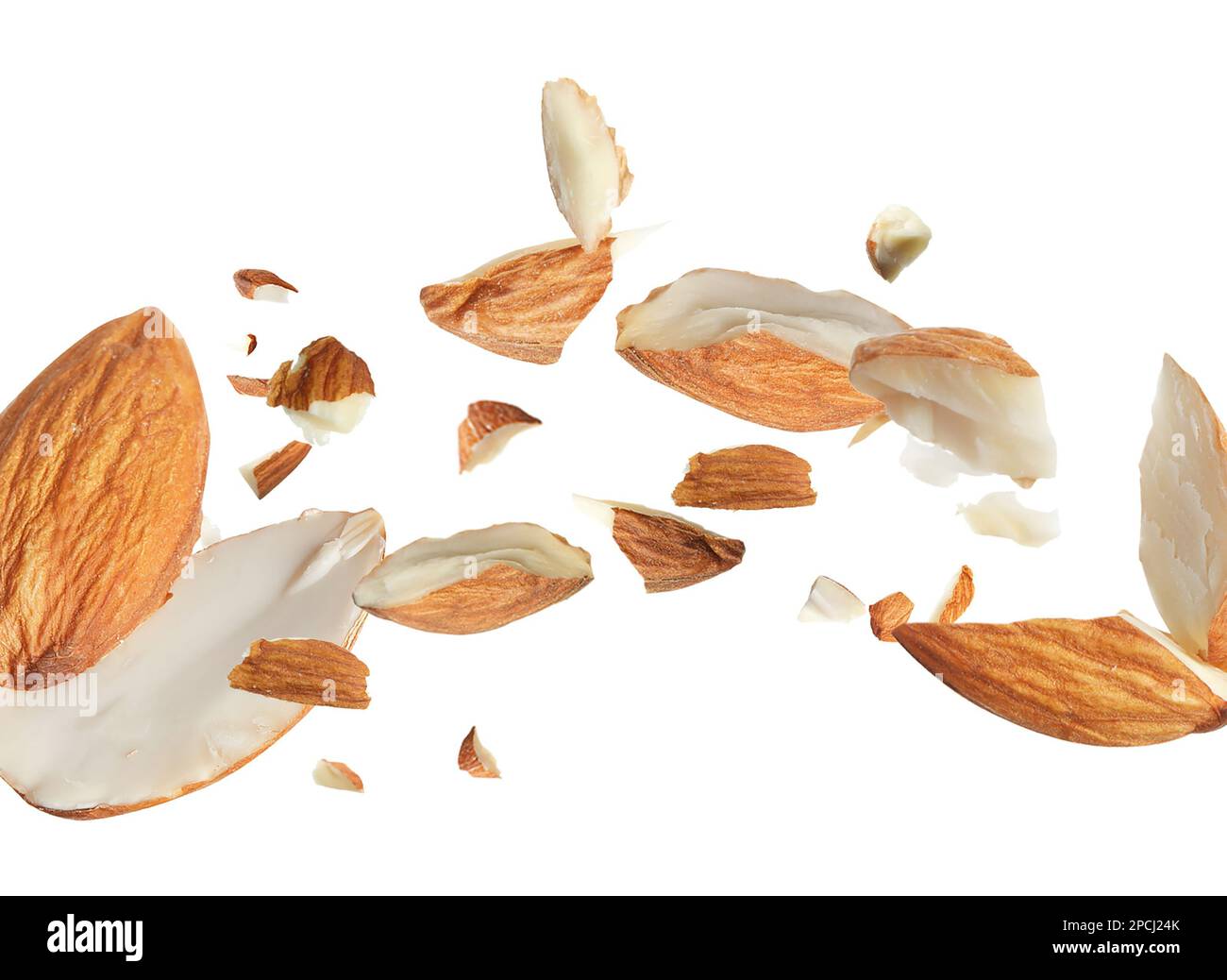Pieces of tasty almonds falling on white background Stock Photo - Alamy