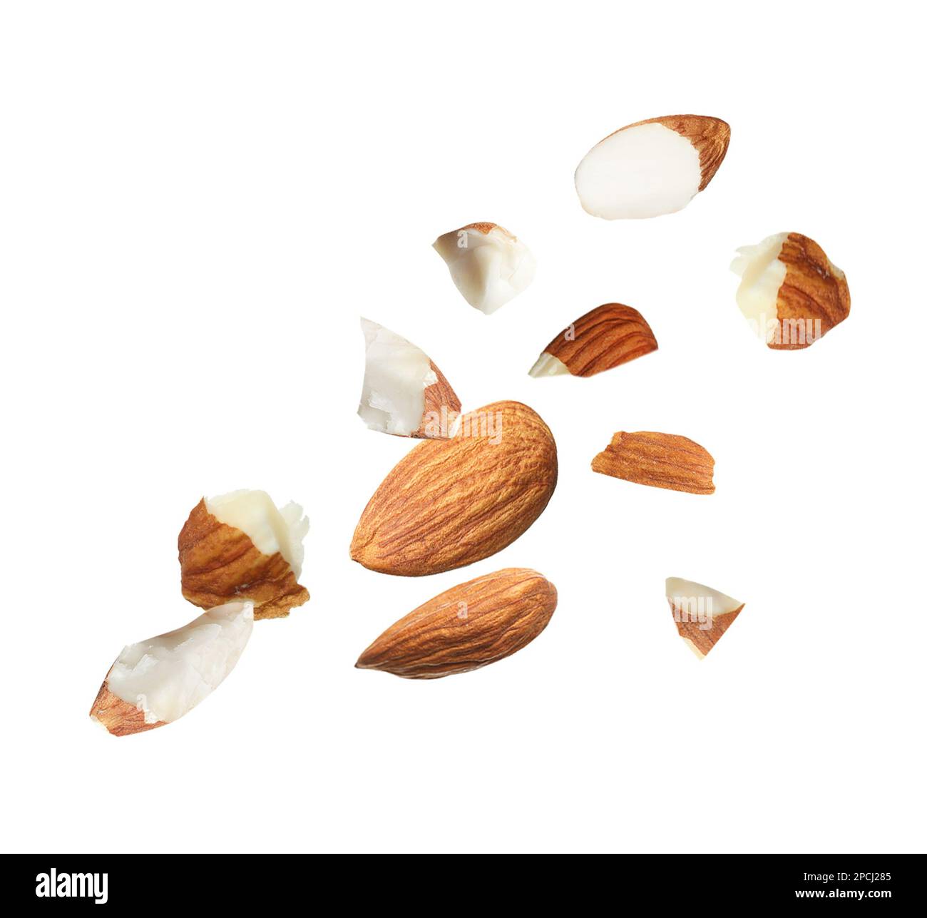 Pieces of tasty almonds falling on white background Stock Photo - Alamy