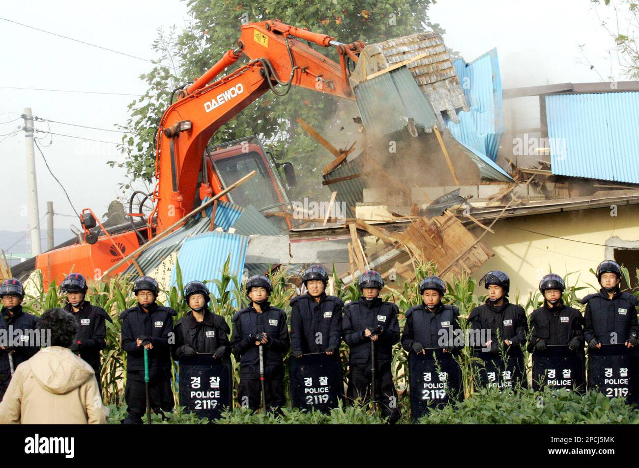 A South Korean female resident looks at her house which was destroyed by a bulldozer in ...