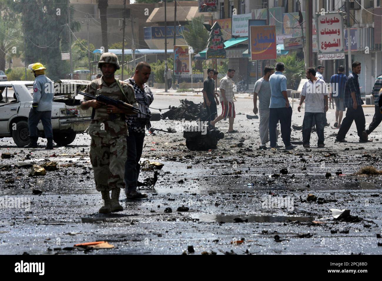 An Iraqi army soldier stands guard at the site of a car bomb explosion ...