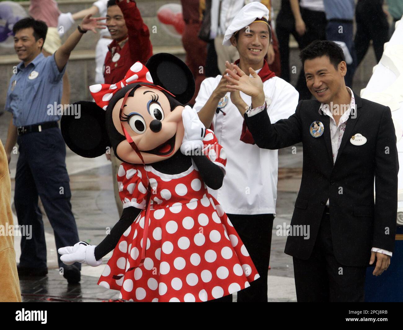 Disney character Minnie Mouse, Hong Kong singer Jacky Cheung, right, and staff members celebrate ...