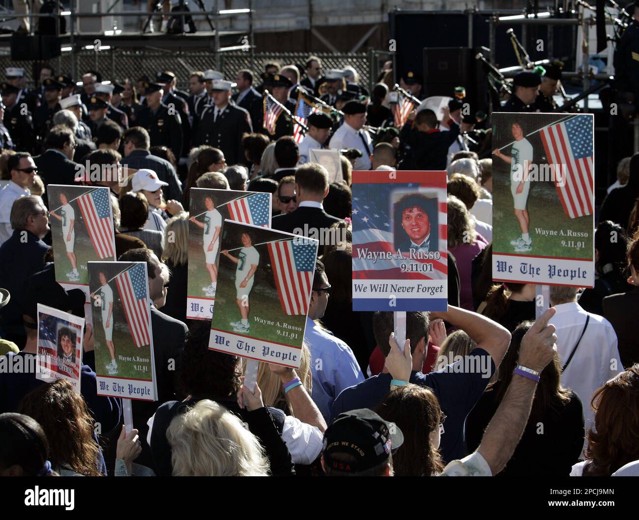 People hold up photos of victim Wayne Alan Russo, of Union, N.J., while ...