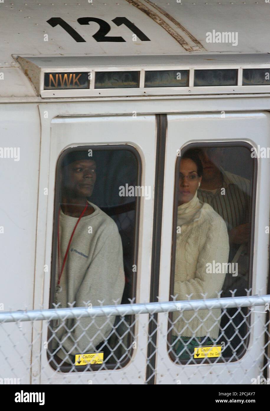 Passengers riding a PATH commuter train stare out the window as they ...