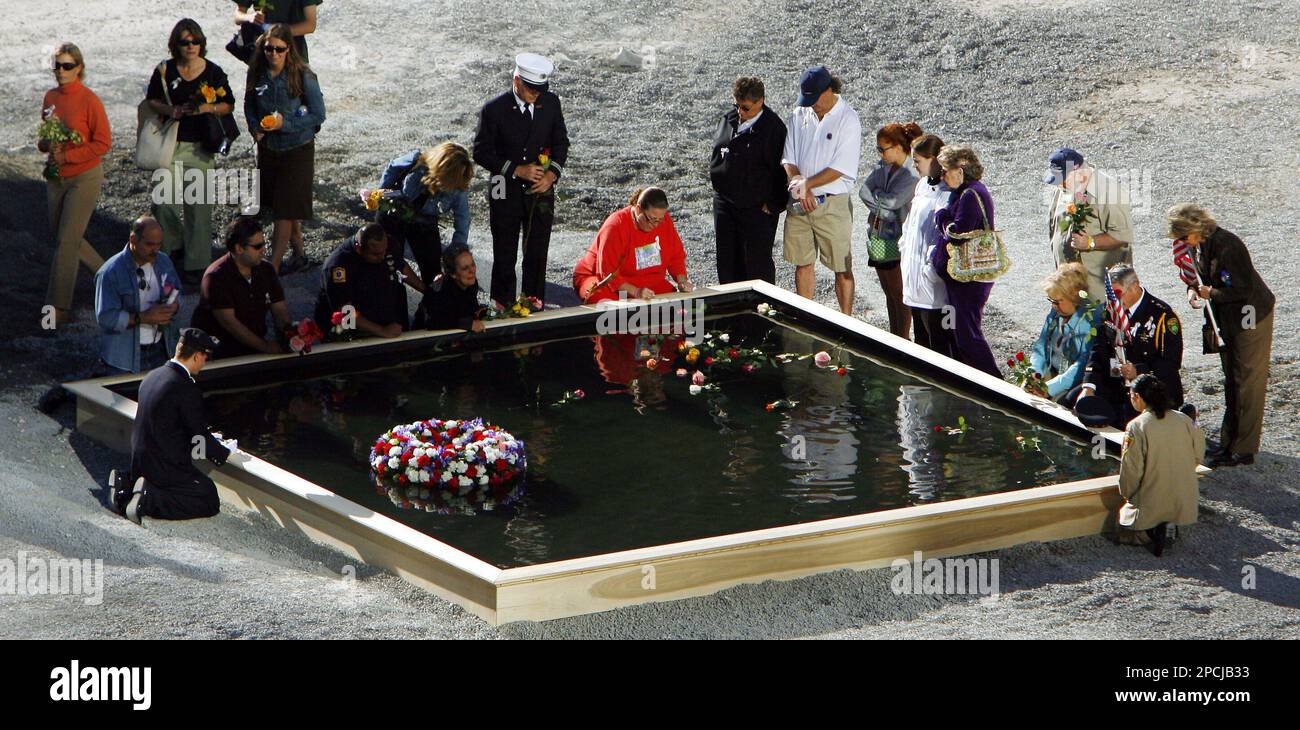 Family members gather at the edge of one of two reflecting pools during ...