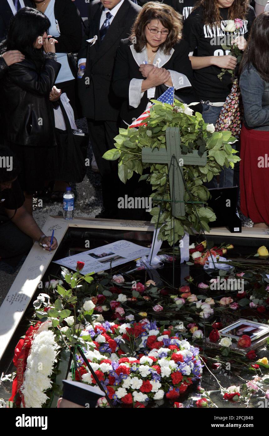 Family members gather at a reflecting pool during a ceremony Monday ...
