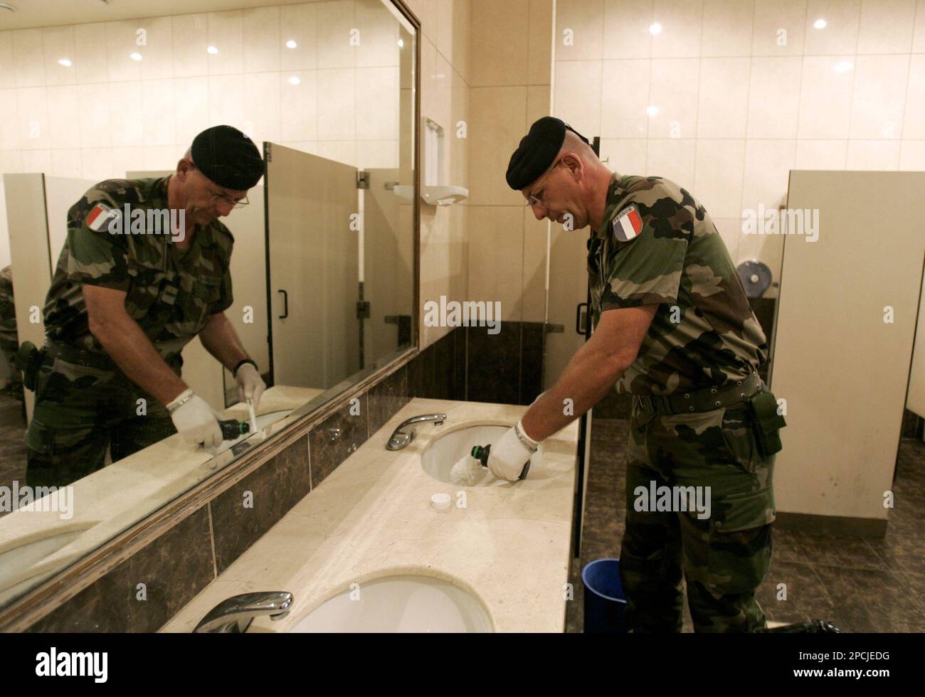 A French U.N. peacekeeper cleans a sink inside toilet facilities at a ...