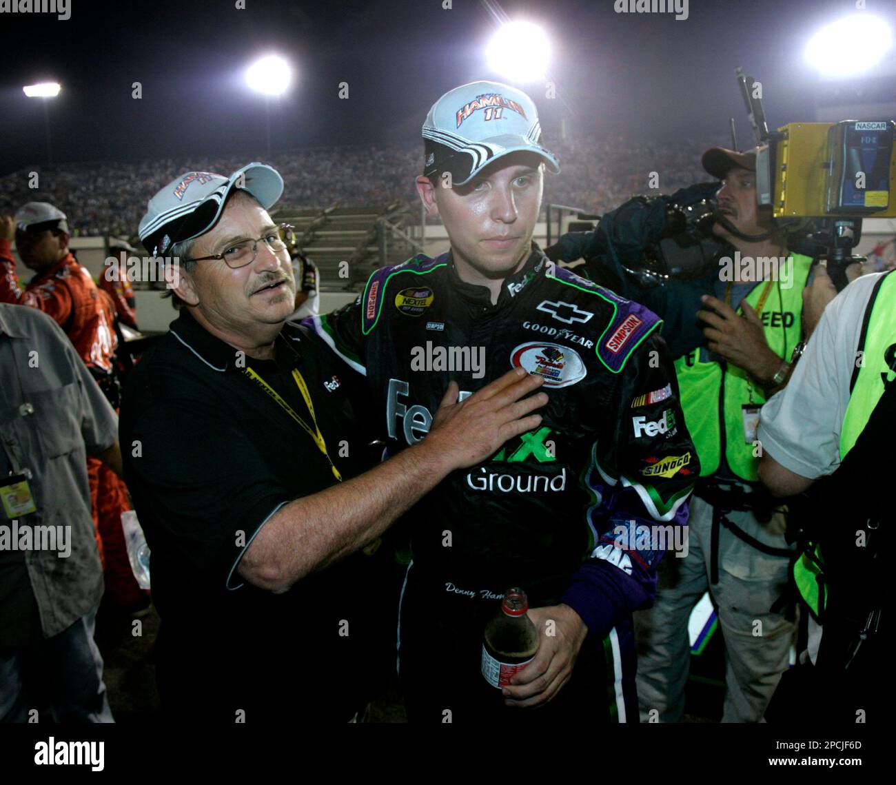 Denny Hamlin gets a hug from his father, Dennis, left, after making the ...