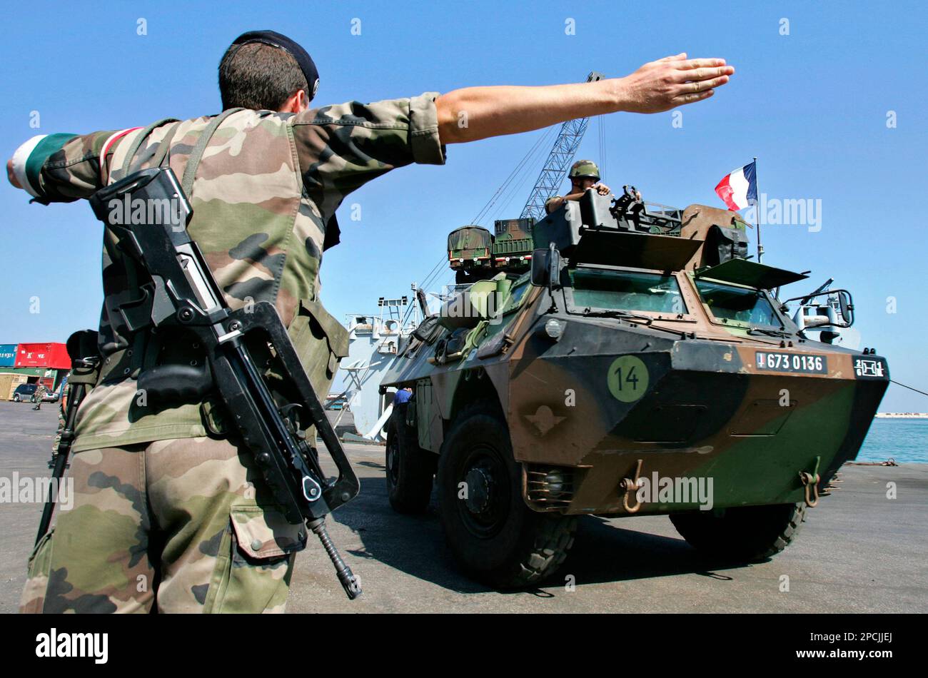 A French U.N. peacekeeper directs an armored personnel carrier as it is ...