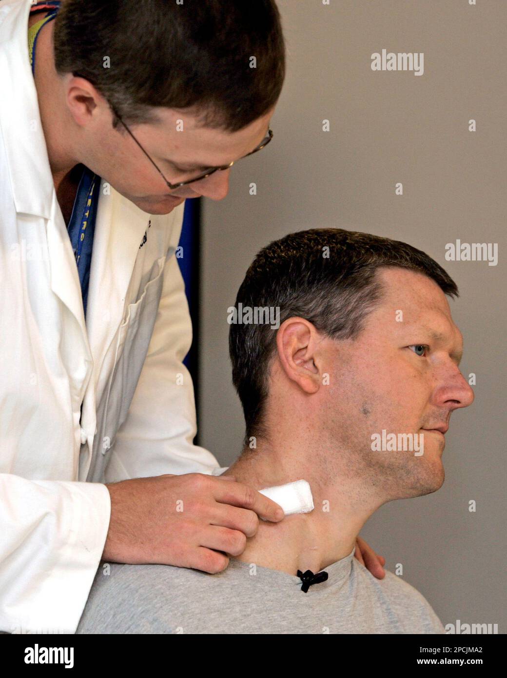 Dr. Jeffrey Claridge, left, points to an entrance wound where a bullet ...