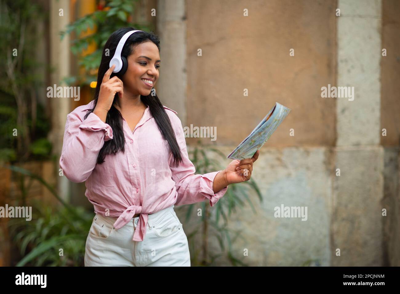 Smiling millennial african american woman in casual and wireless ...