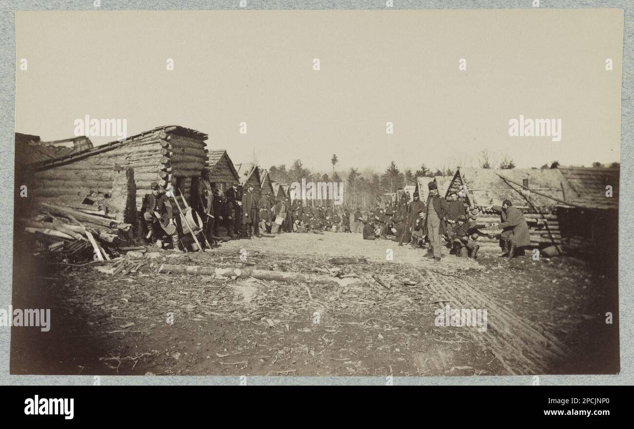 Union soldiers, in camp, posed in front of log buildings. Title devised ...