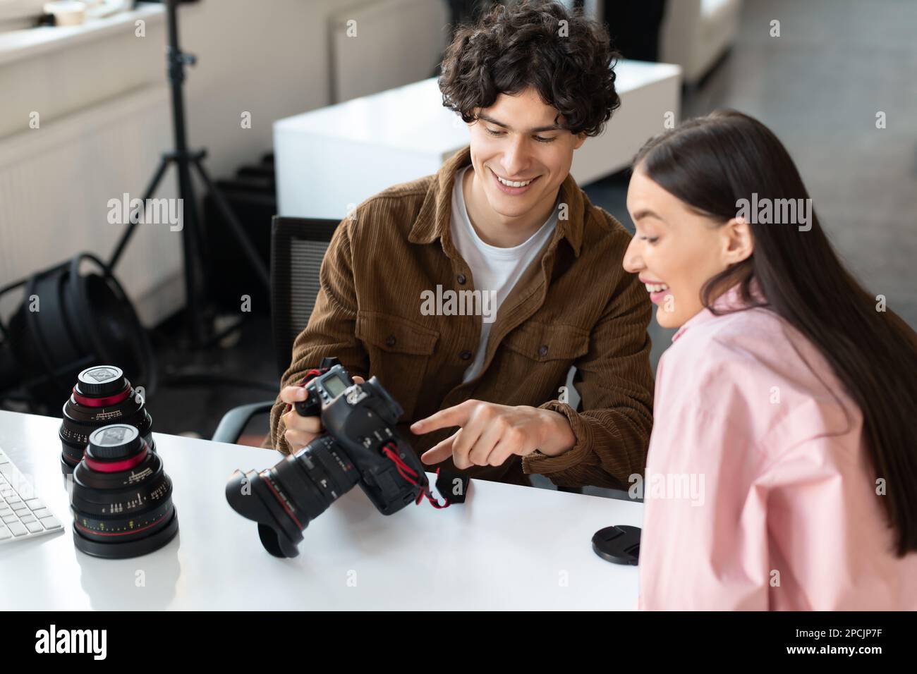 Male photographer and woman model discussing photos with camera ...