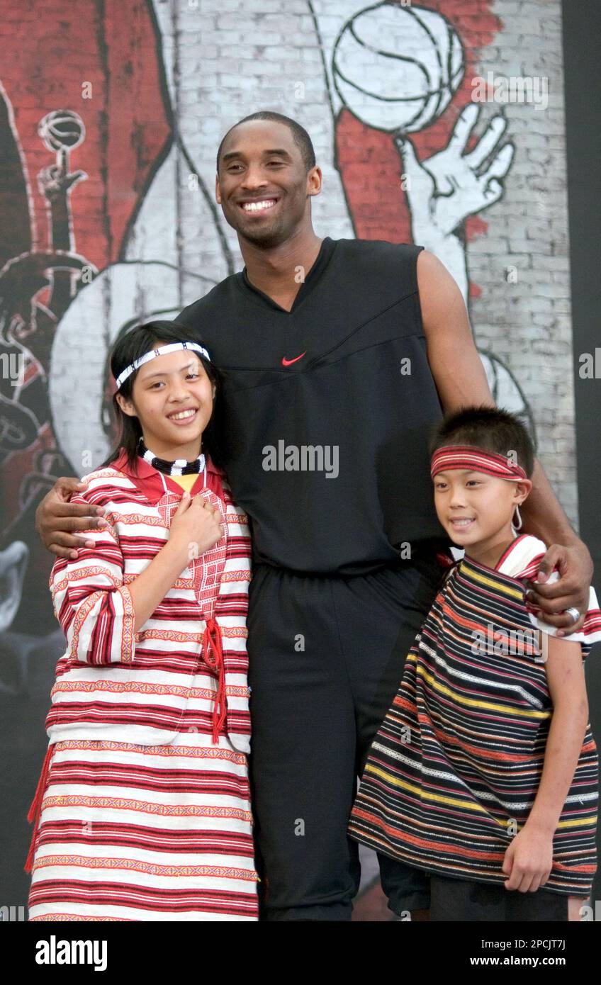 NBA star player Kobe Bryant of Los Angeles Lakers hugs two Taiwanese ...