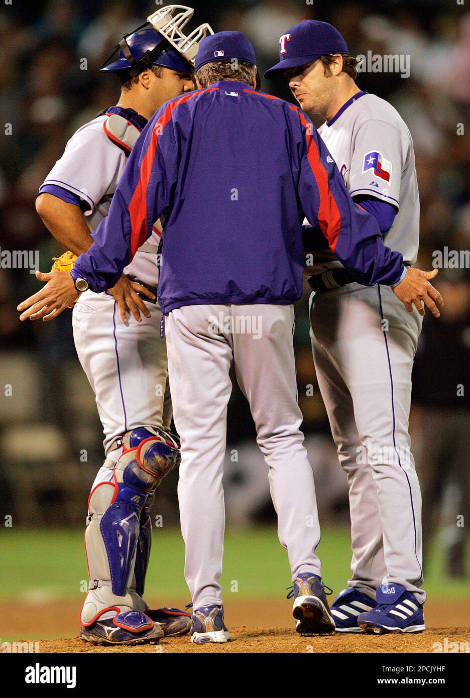 Texas Rangers' pitching coach Mark Connor, center, speaks with Adam ...
