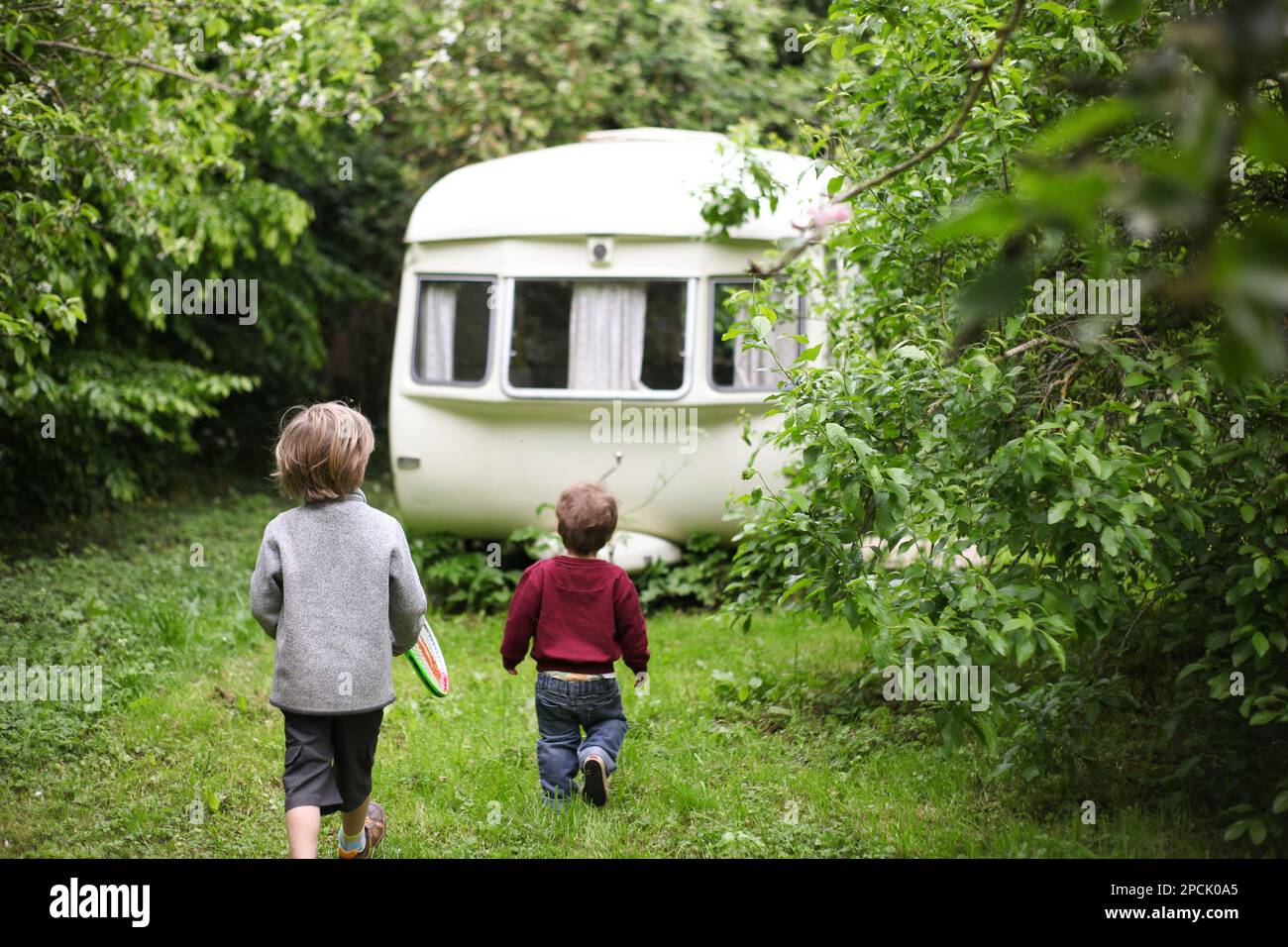 two children walking towards a vintage caravan Stock Photo - Alamy