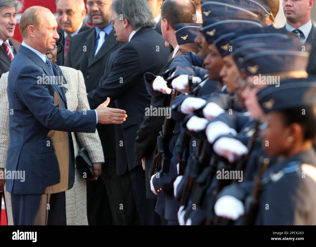 Russian President Vladimir Putin, left, holds out his hand to a ...
