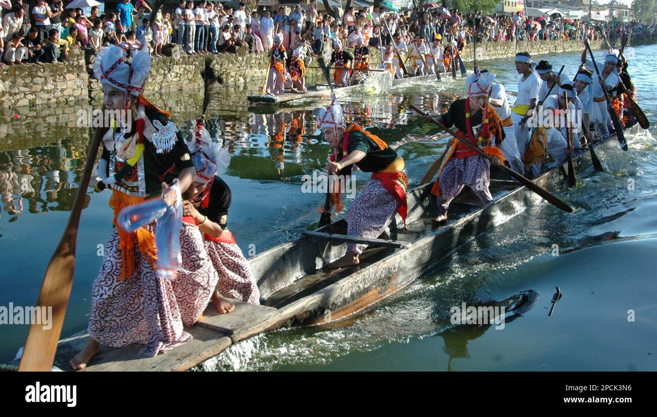 People dressed in traditional costume participate in a traditional boat ...
