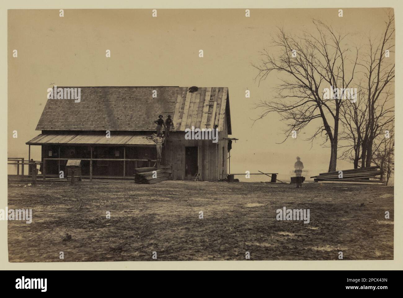 Workers constructing a wood building. Title devised by Library staff ...