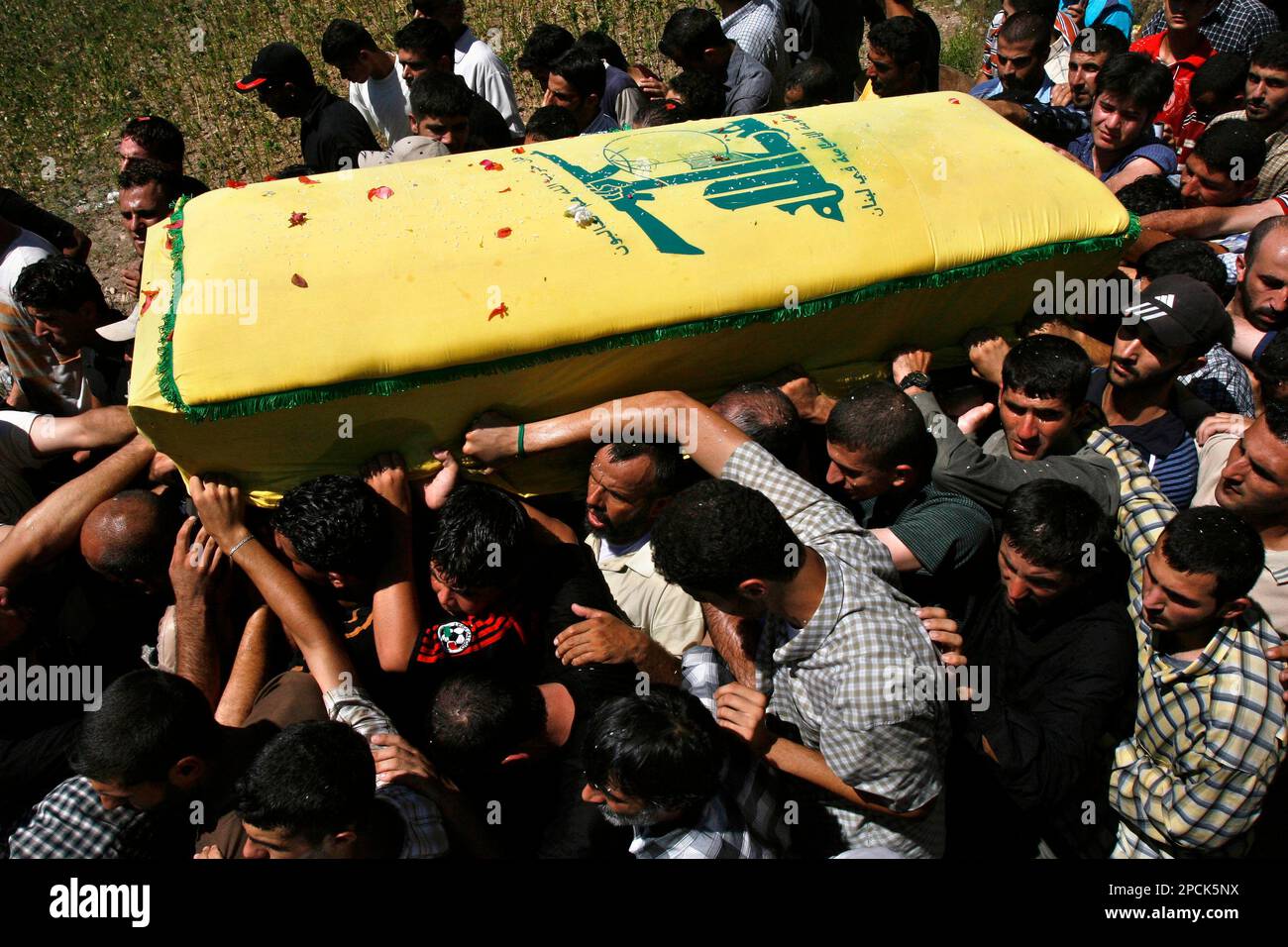 Lebanese mourners carry the coffin, draped in a Hezbollah flag, of ...