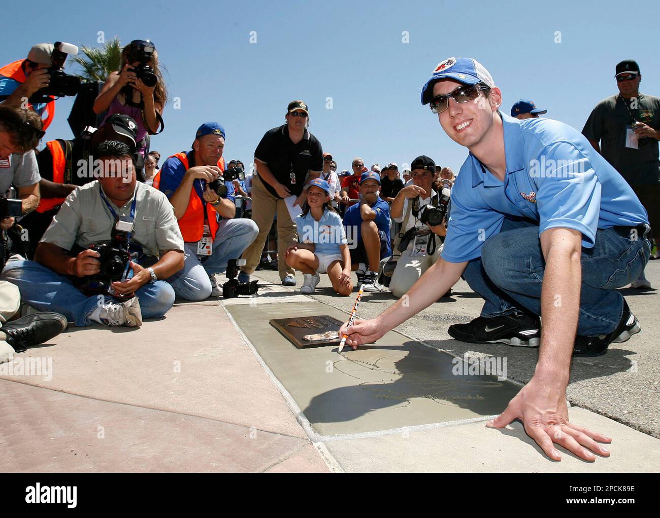 Driver Kyle Busch poses for photographers while signing his name in wet ...