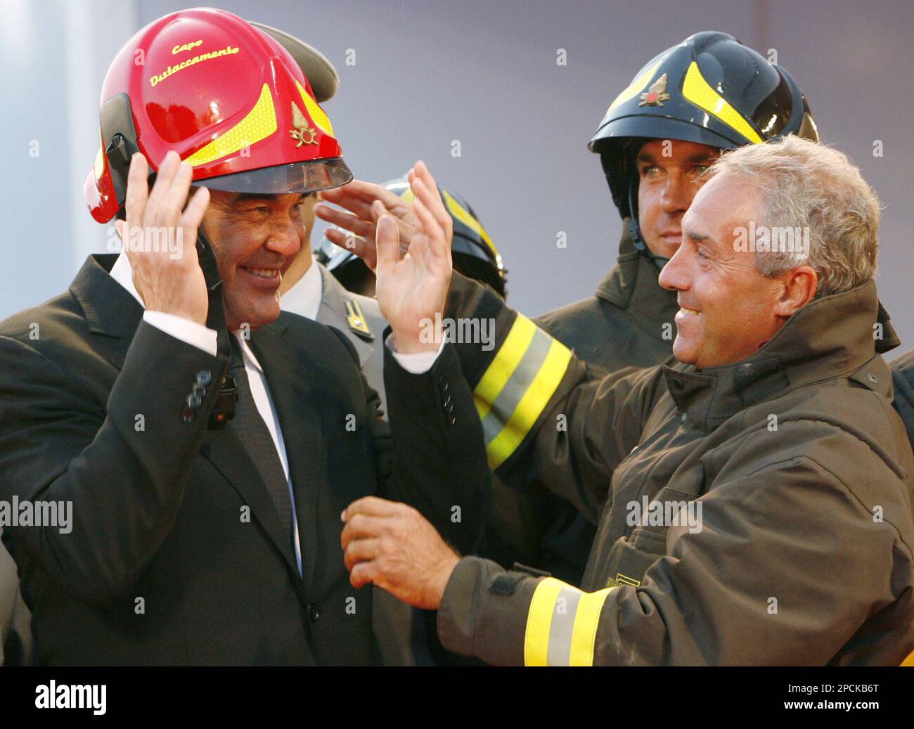 US director Oliver Stone, left, is helped by an Italian firefighter to ...