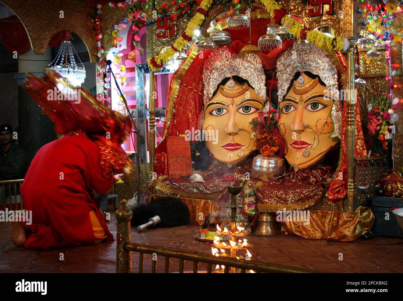 A Hindu temple priest, left, sways his body while performing ...