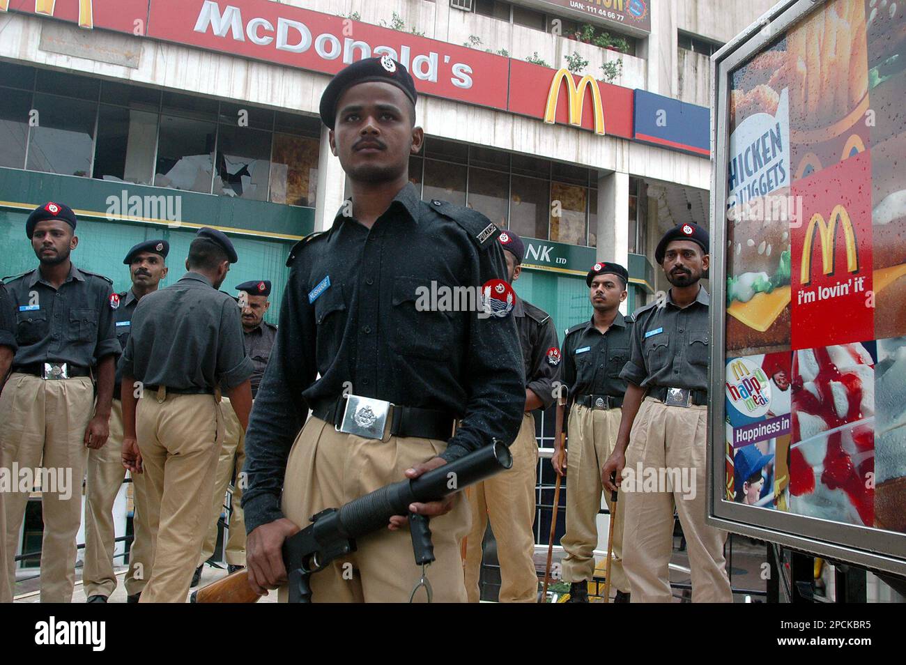 Pakistani police officers stand alert in front of an outlet of ...