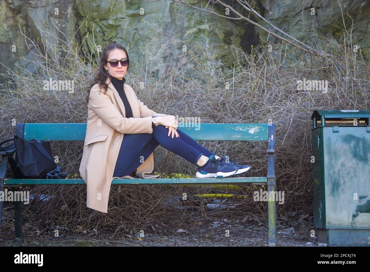 Portrait of a woman sitting on bench Stock Photo - Alamy
