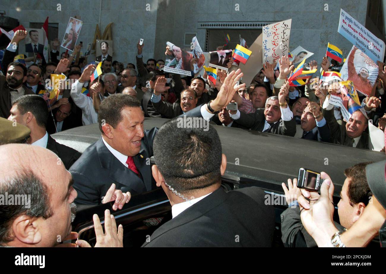 Thousands of Syrians line the streets of the capital Damascus holding ...