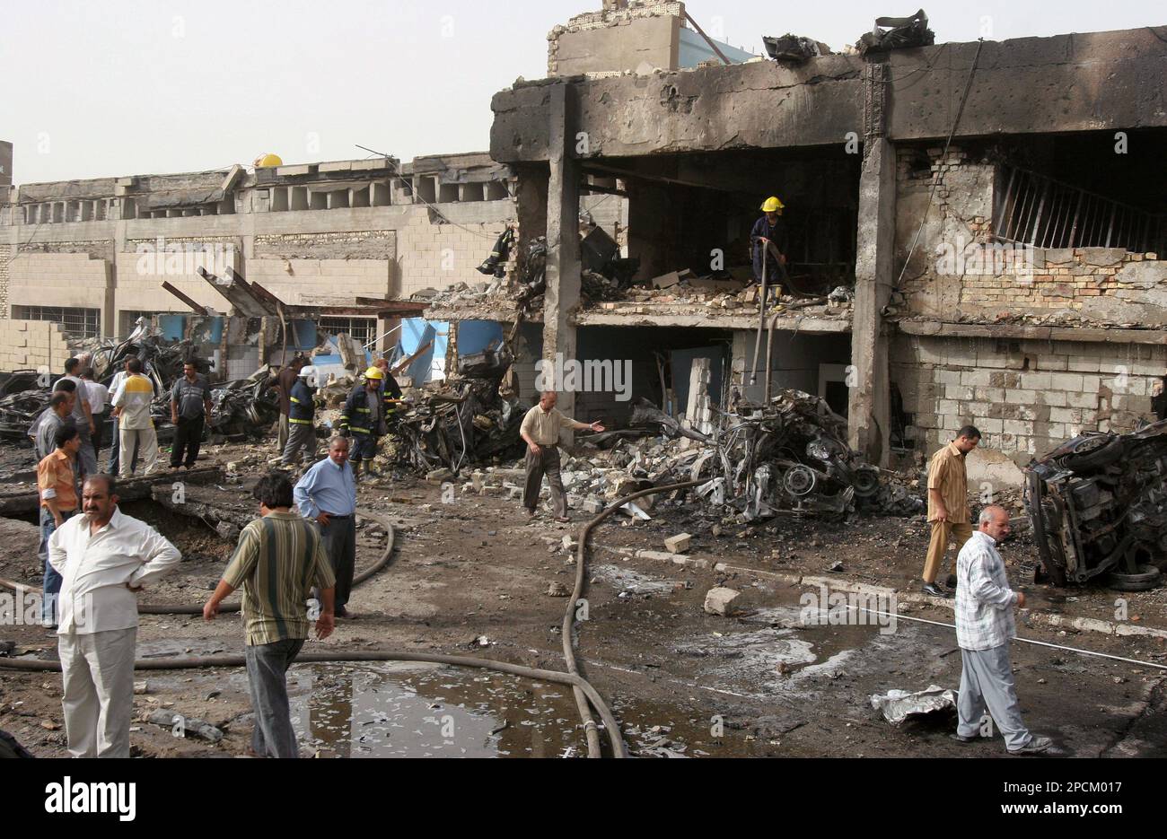Iraqi civil defense workers clear debris and rubble following a car ...