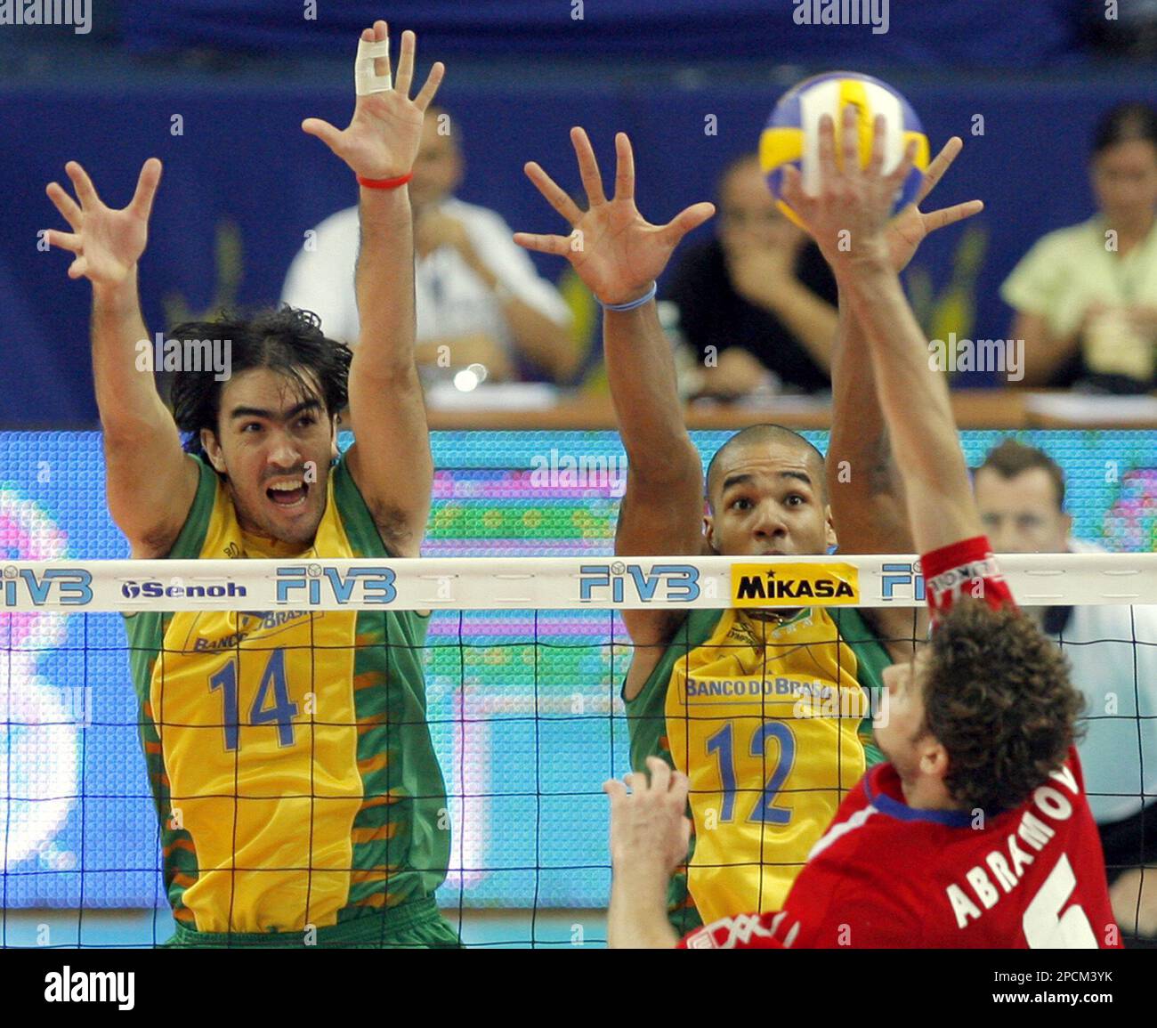 Pavel Abramov of Russia, right, strikes the ball which is blocked by ...