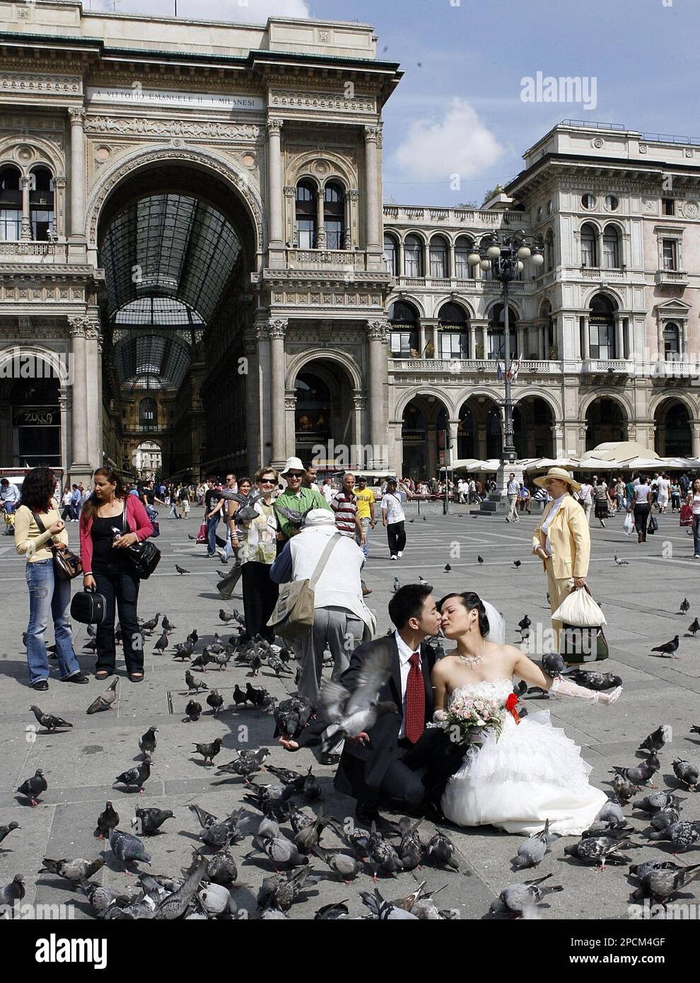 A newlywed Chinese couple exchange a kiss as they pose for a picture in ...