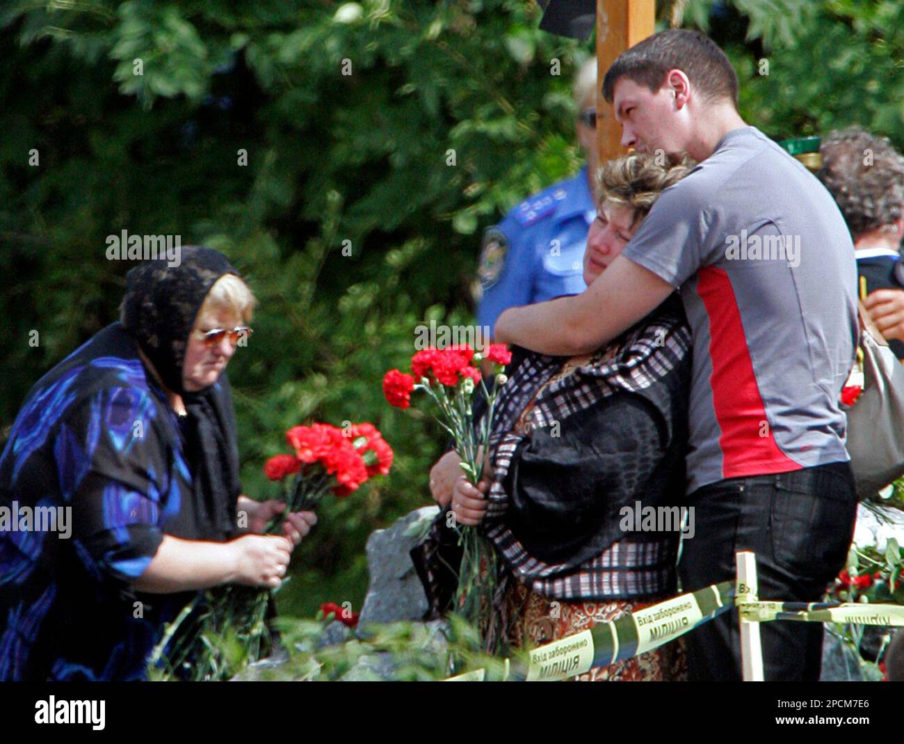 Relatives of a Tu-154 crash victims cry at the cordoned field where the ...