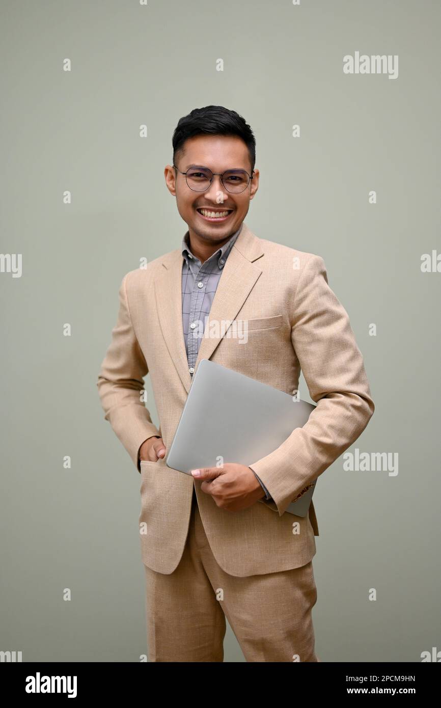 Happy and smiling millennial Asian businessman in formal business suit ...
