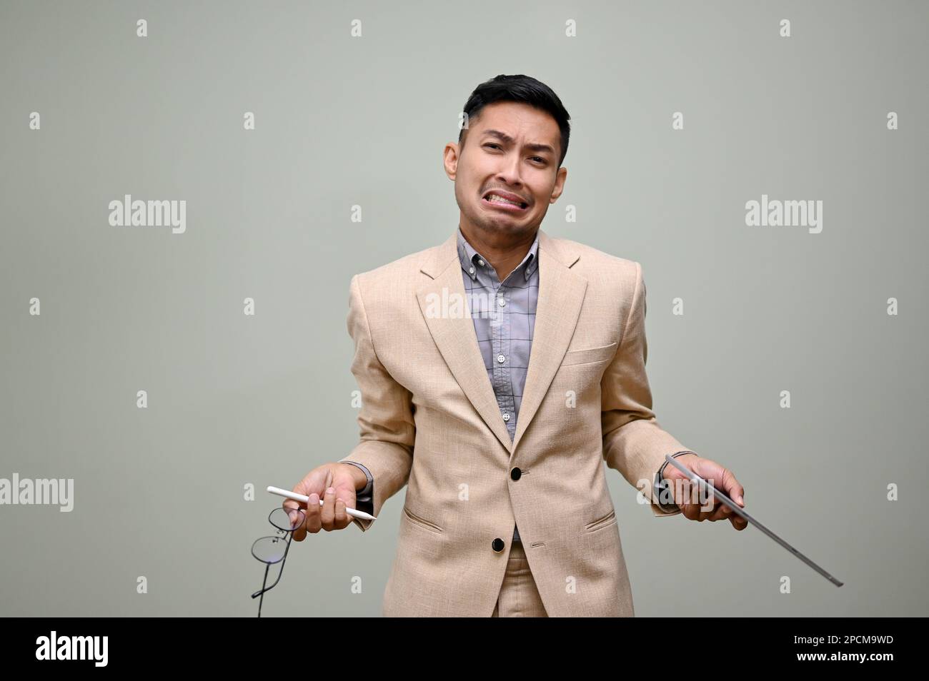 Reluctant and unpleasant millennial Asian businessman or male office ...